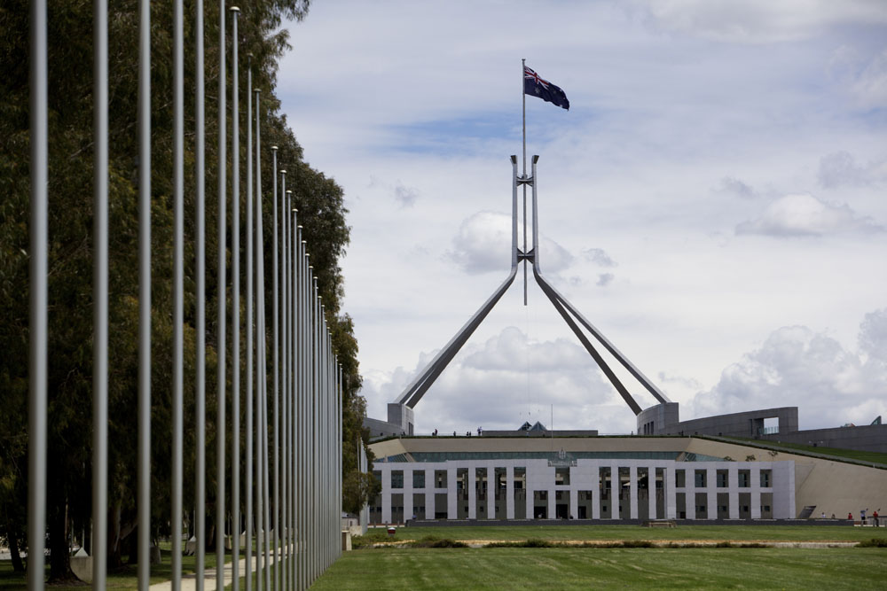 An Australian flag rises above the nation's capital in Canberra ...